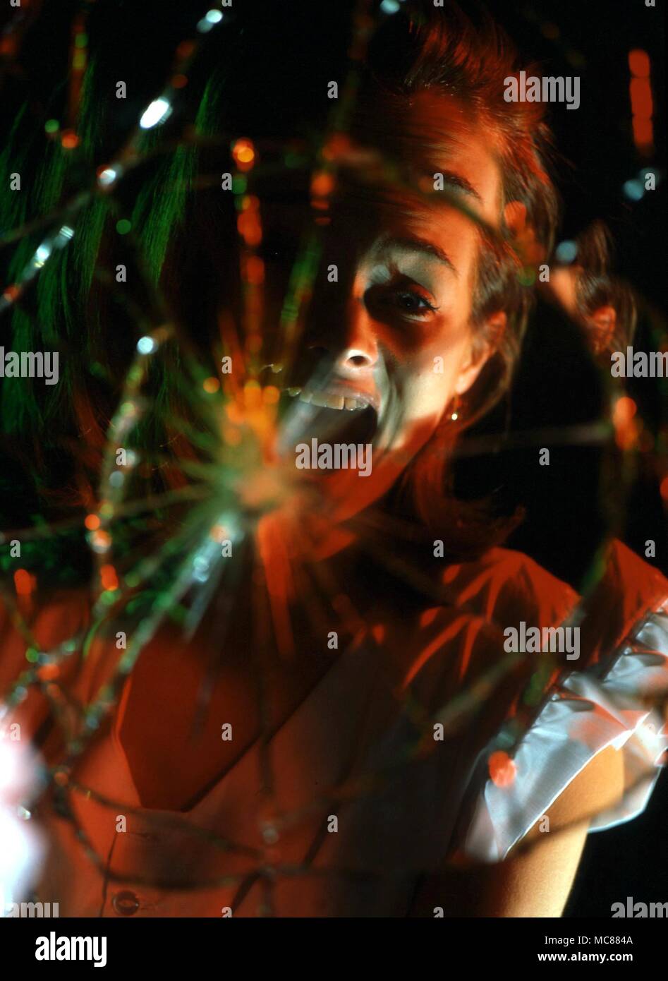 Fantasy - fear. A girl screaming into a broken mirror Stock Photo - Alamy