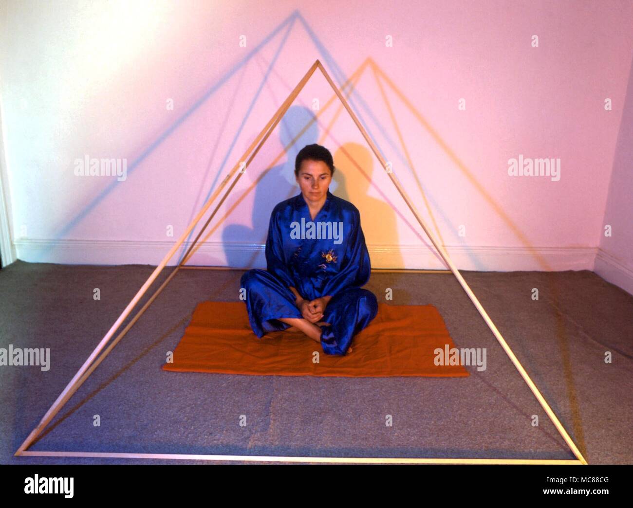 PYRAMIDOLOGY Girl sitting beneath the framework of a pyramid set tot he ...