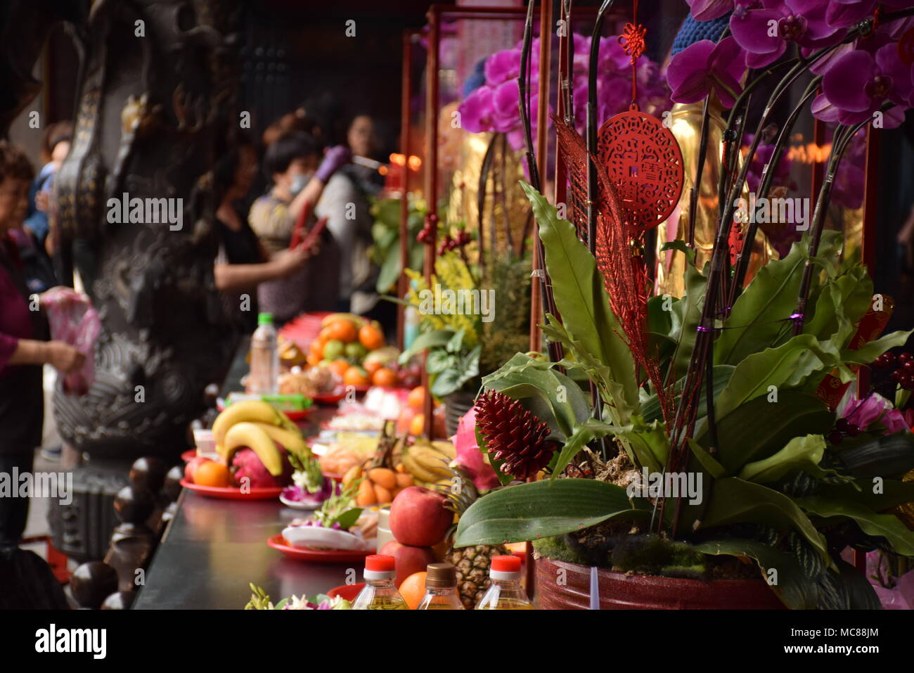 Food, fruits, flowers and other offerings on a table inside Longshan ...