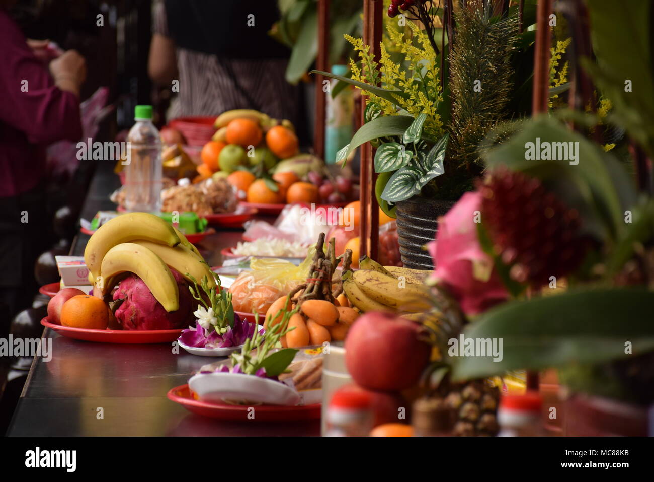 Food, fruits, flowers and other offerings on a table inside Longshan ...