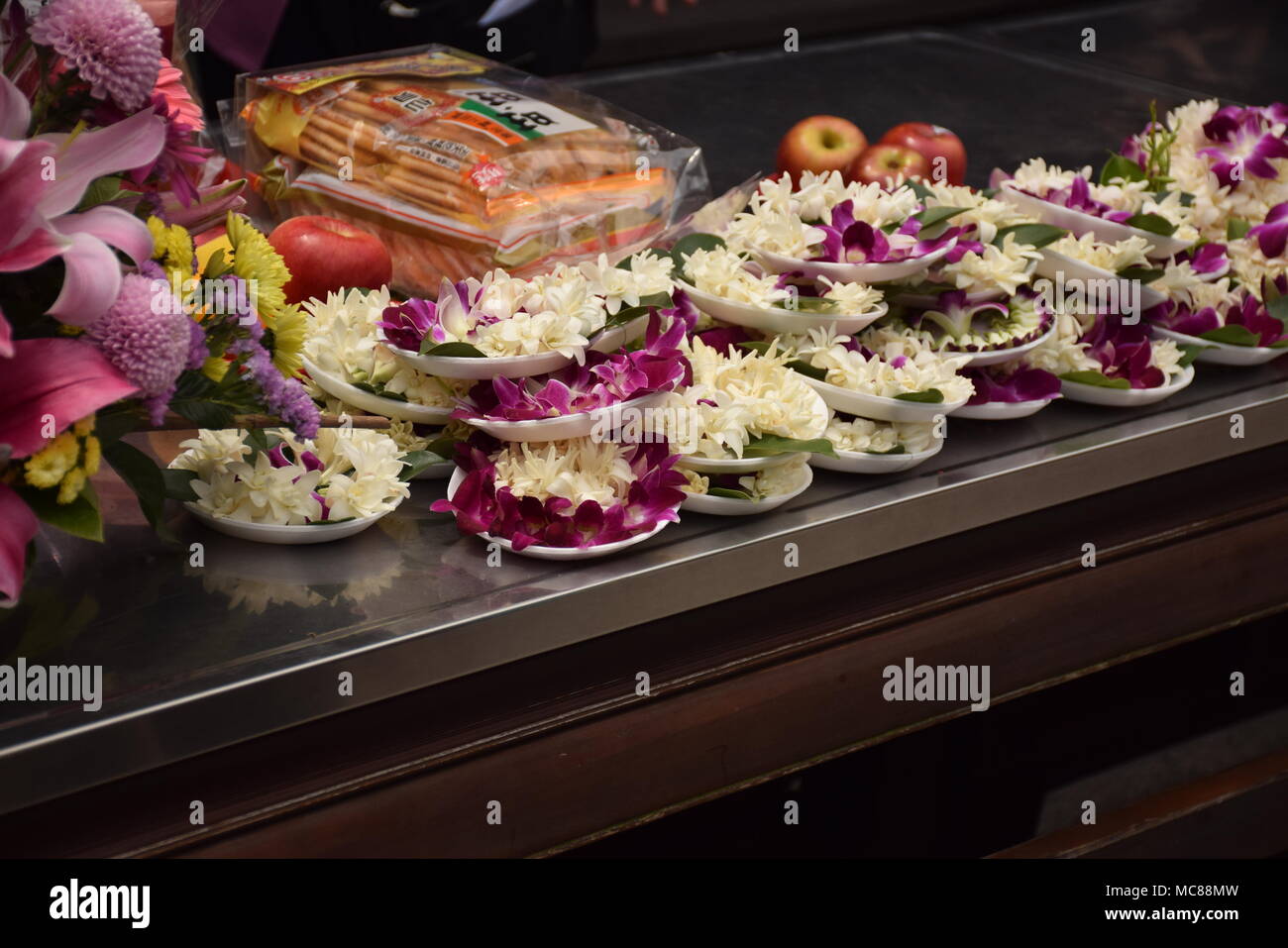 Food, fruits, flowers and other offerings on a table inside Longshan ...