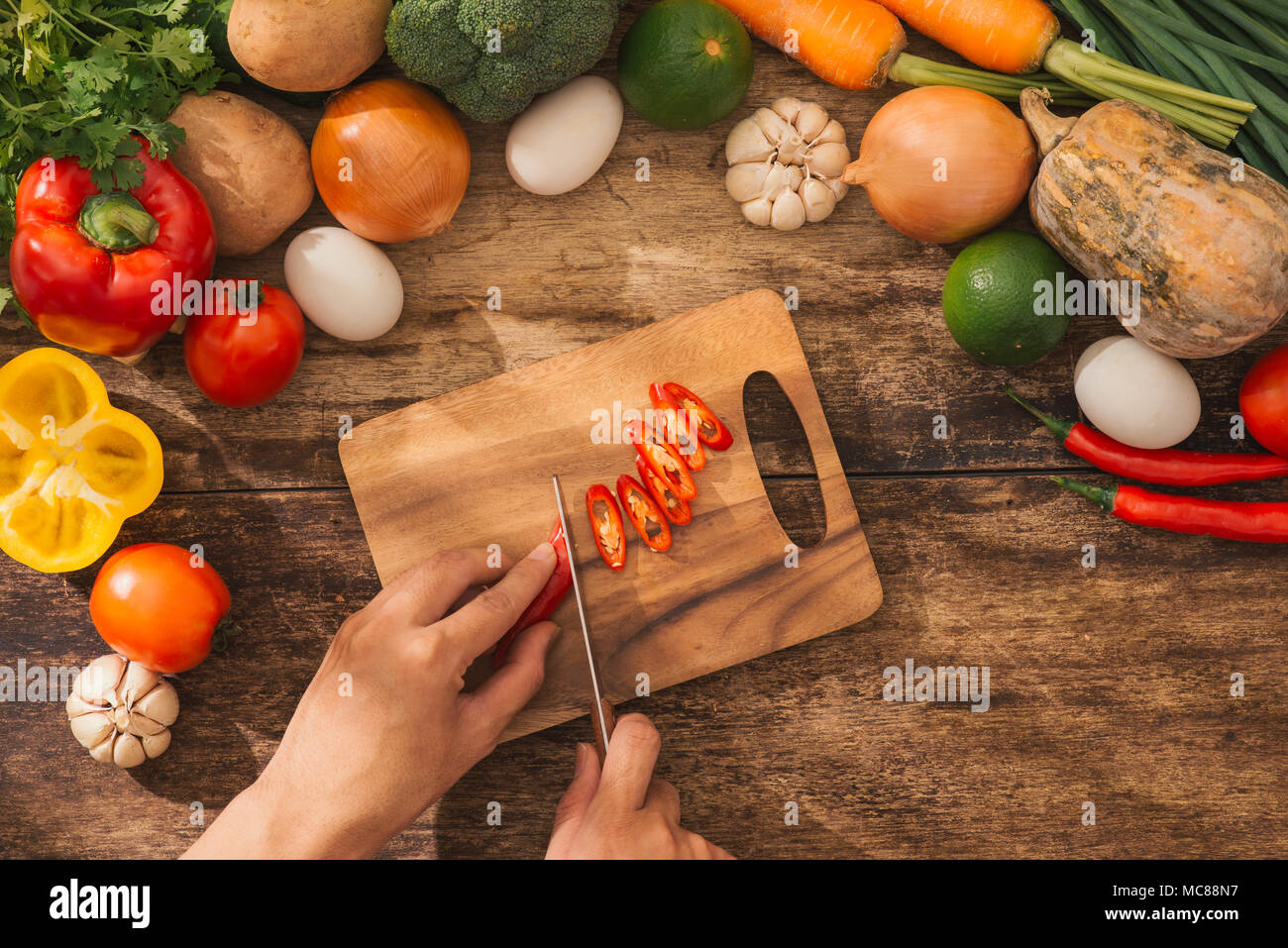 Cutting red chili. Male hands cooking vegetables salad in kitchen. Top ...