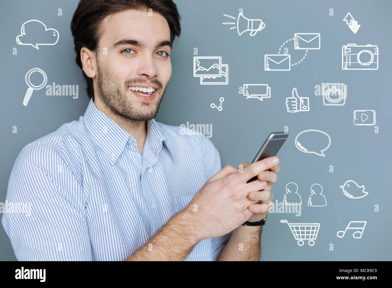 Young teacher typing messages to his students and smiling Stock Photo ...
