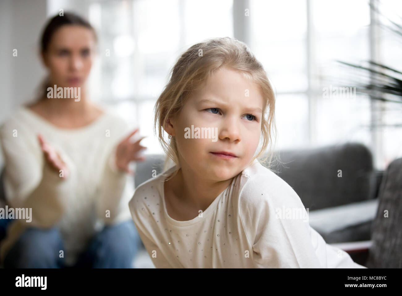 Sulky angry offended kid girl pouting ignoring mother scolding her for ...