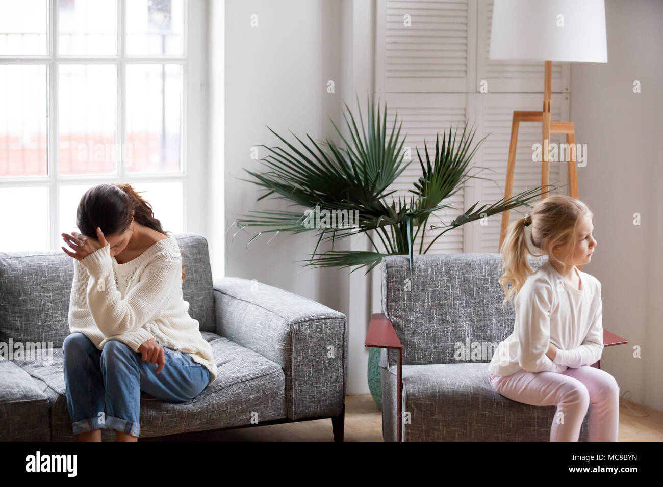 Sad tired mother and sulky angry offended child girl not talking after ...