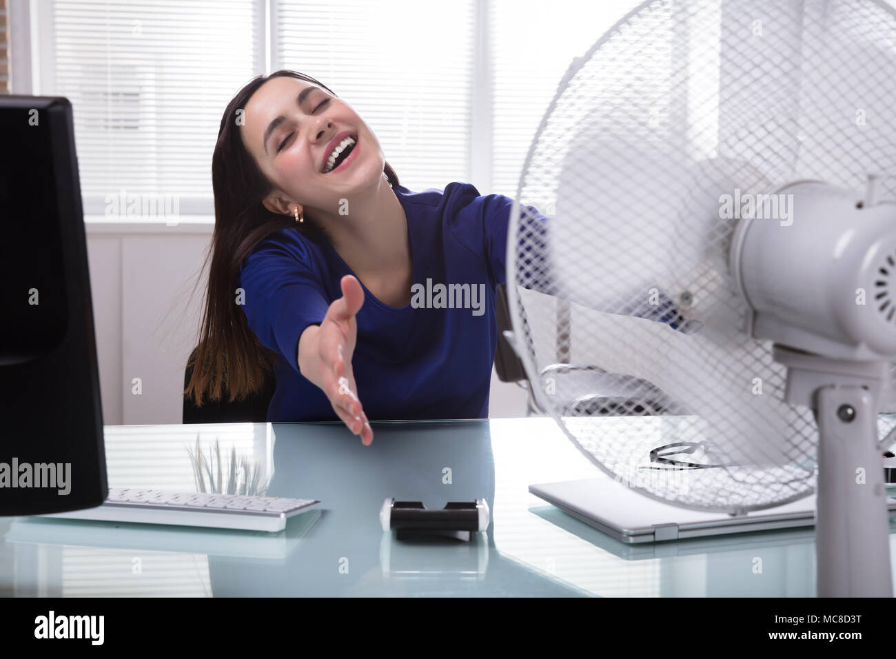 Woman sitting in front of an electric fan hi-res stock photography and ...