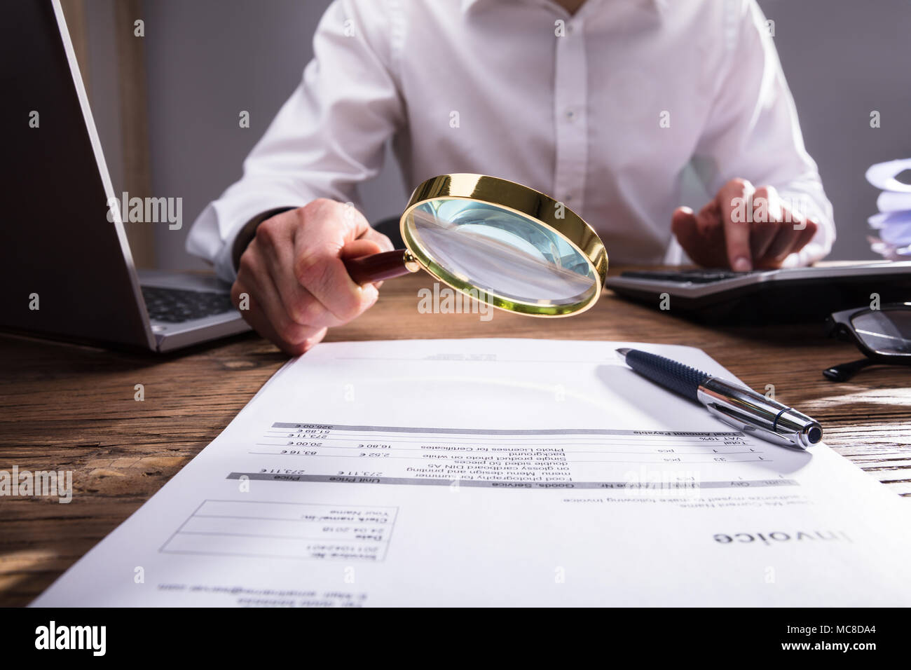 Businessperson Analyzing Bill Through Magnifying Glass On Desk Stock ...