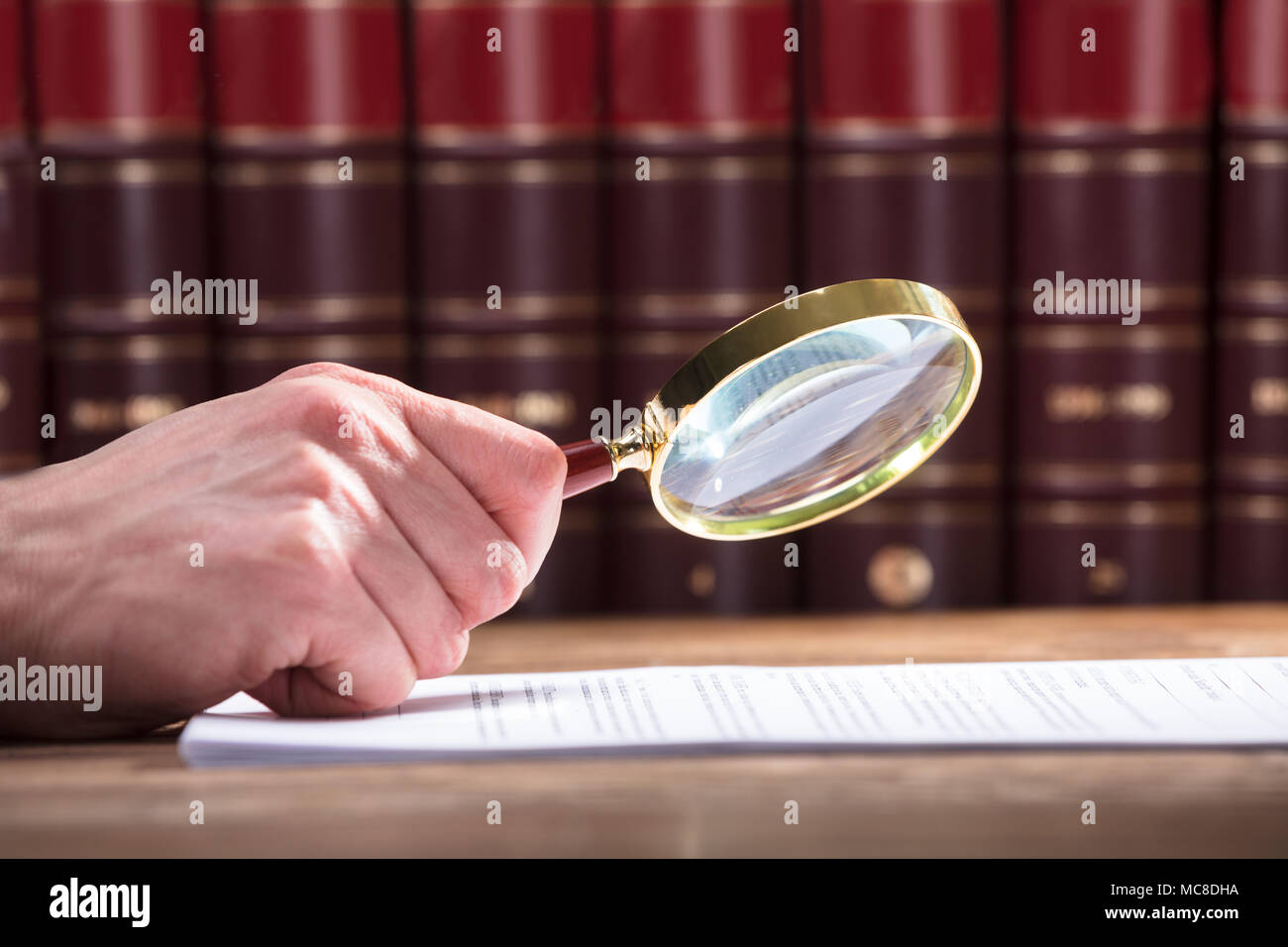 Human Hand Examining Document Through Magnifying Glass Stock Photo - Alamy