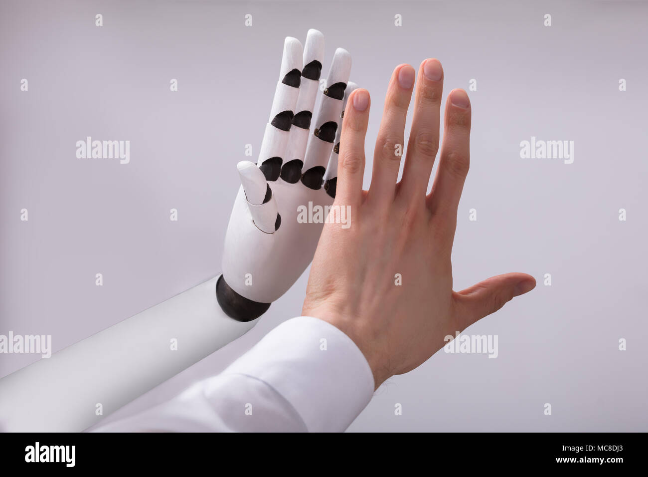 Robot And Man Giving High Five On Grey Background Stock Photo - Alamy