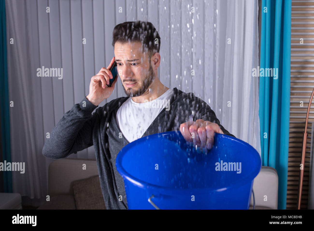 Worried Young Man Calling Plumber While Leakage Water Falling Into ...