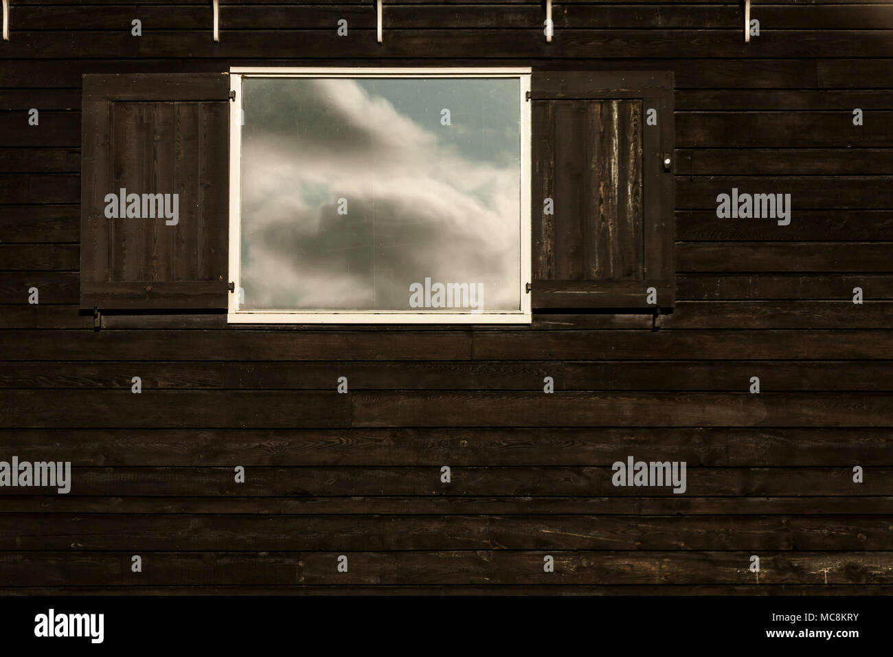 Clouds reflecting in opened old fashioned traditional wood window ...