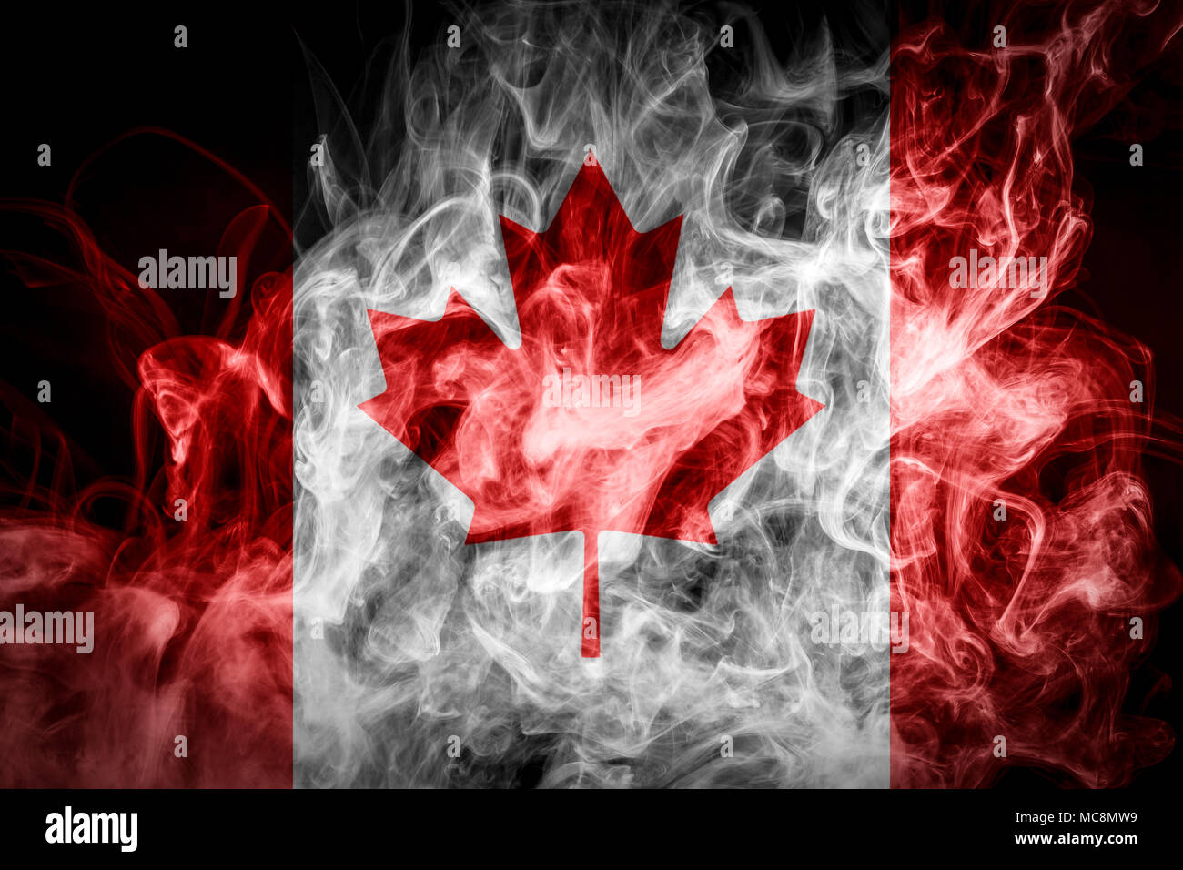 National flag of Canada from thick colored smoke on a black isolated ...