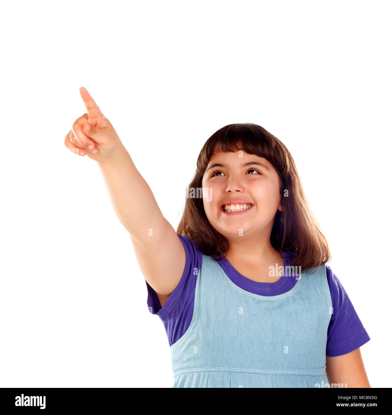 Smiling girl pointing something with her finger isolated on a white ...