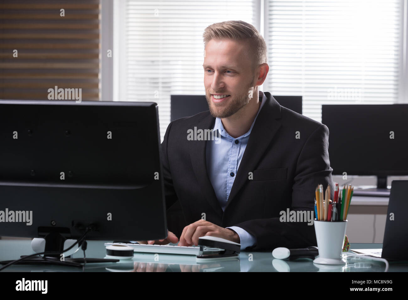 Happy Businessman Working On Computer In Office Stock Photo - Alamy