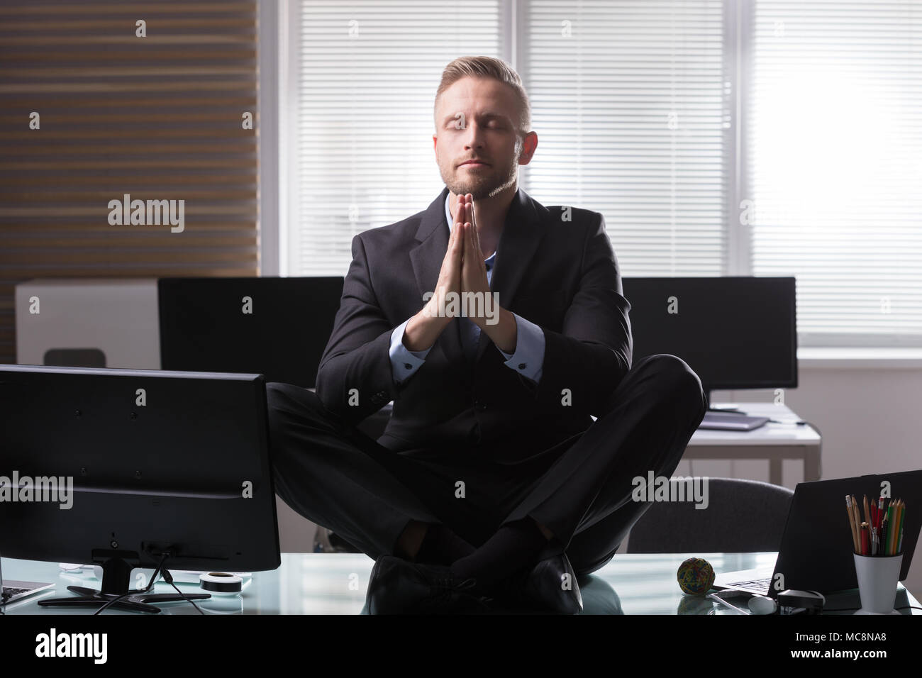 Business man meditating on desk hi-res stock photography and images - Alamy