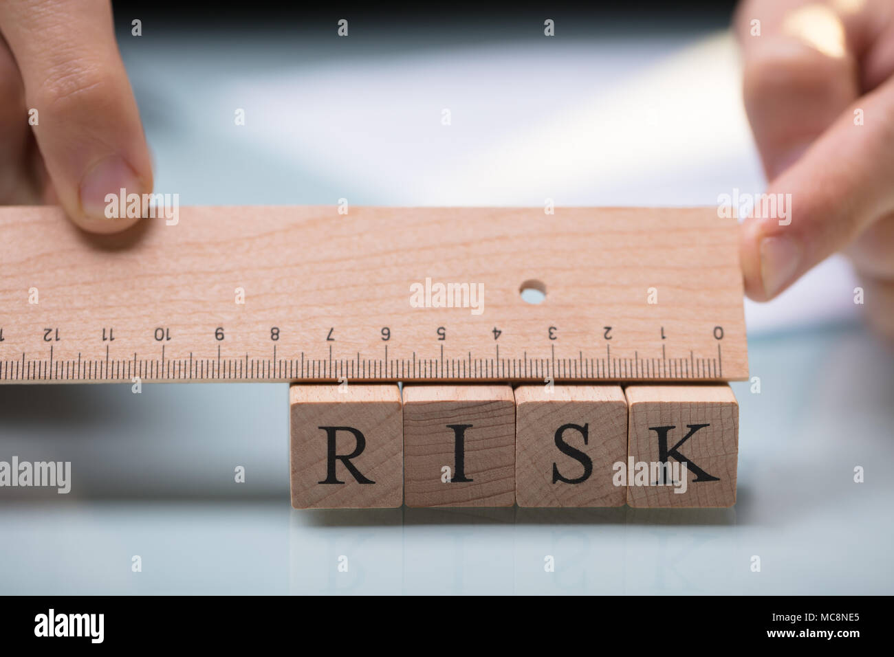 Close-up Of A Businessperson's Hand Measuring Risk Blocks With Wooden ...