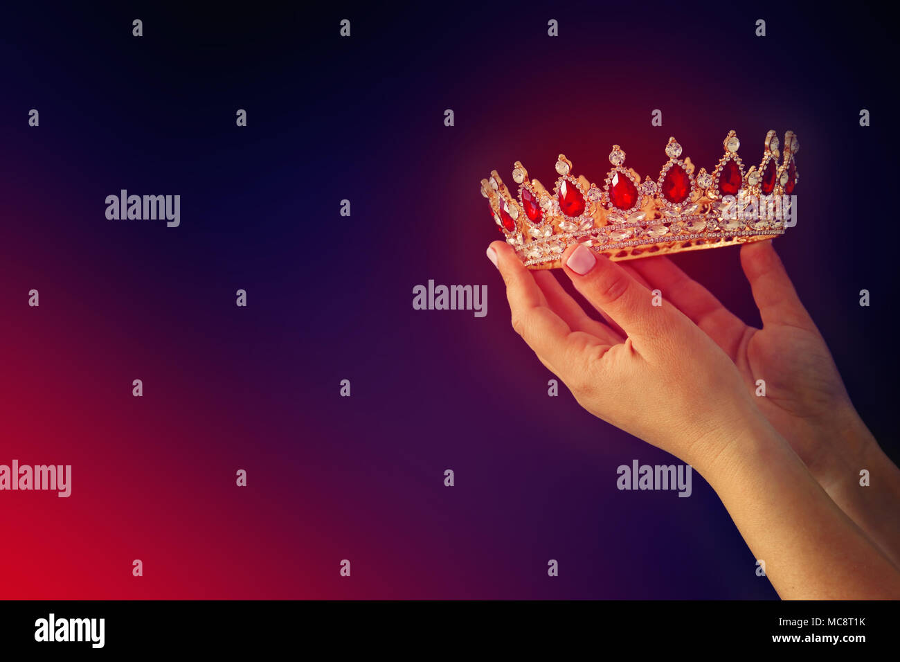 Woman's hand holding a crown for show victory or winning first place ...