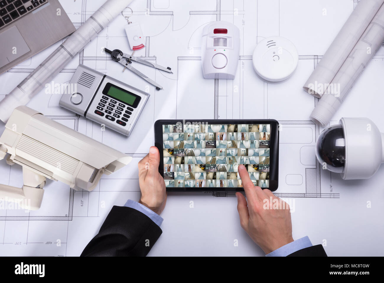High Angle View Of A Person's Hand Holding Digital Tablet With CCTV ...