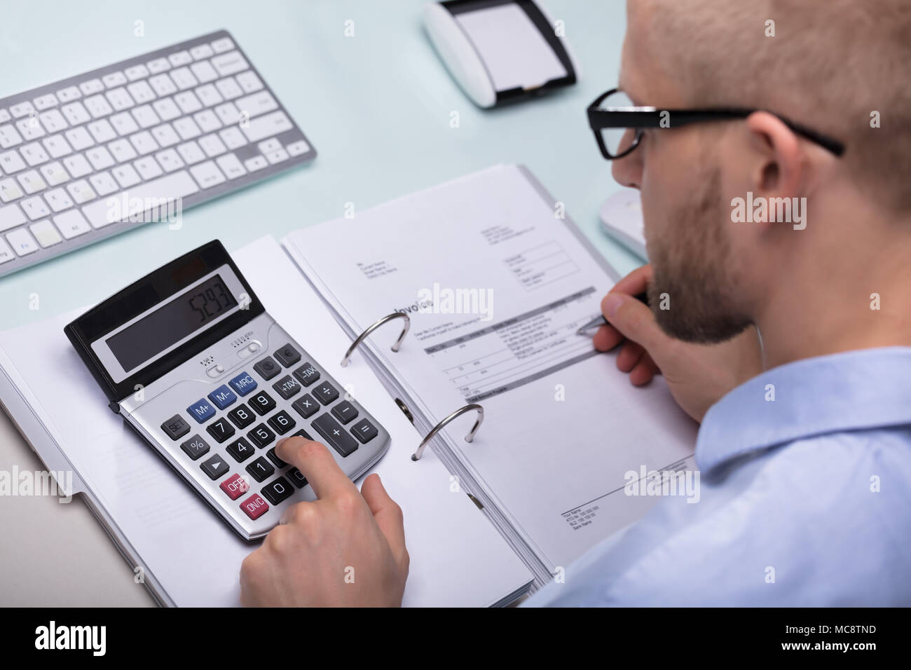Businessman Using Calculator For Calculating Invoice At Desk Stock ... Businessman Using Calculator For Calculating Invoice At Desk Stock ...