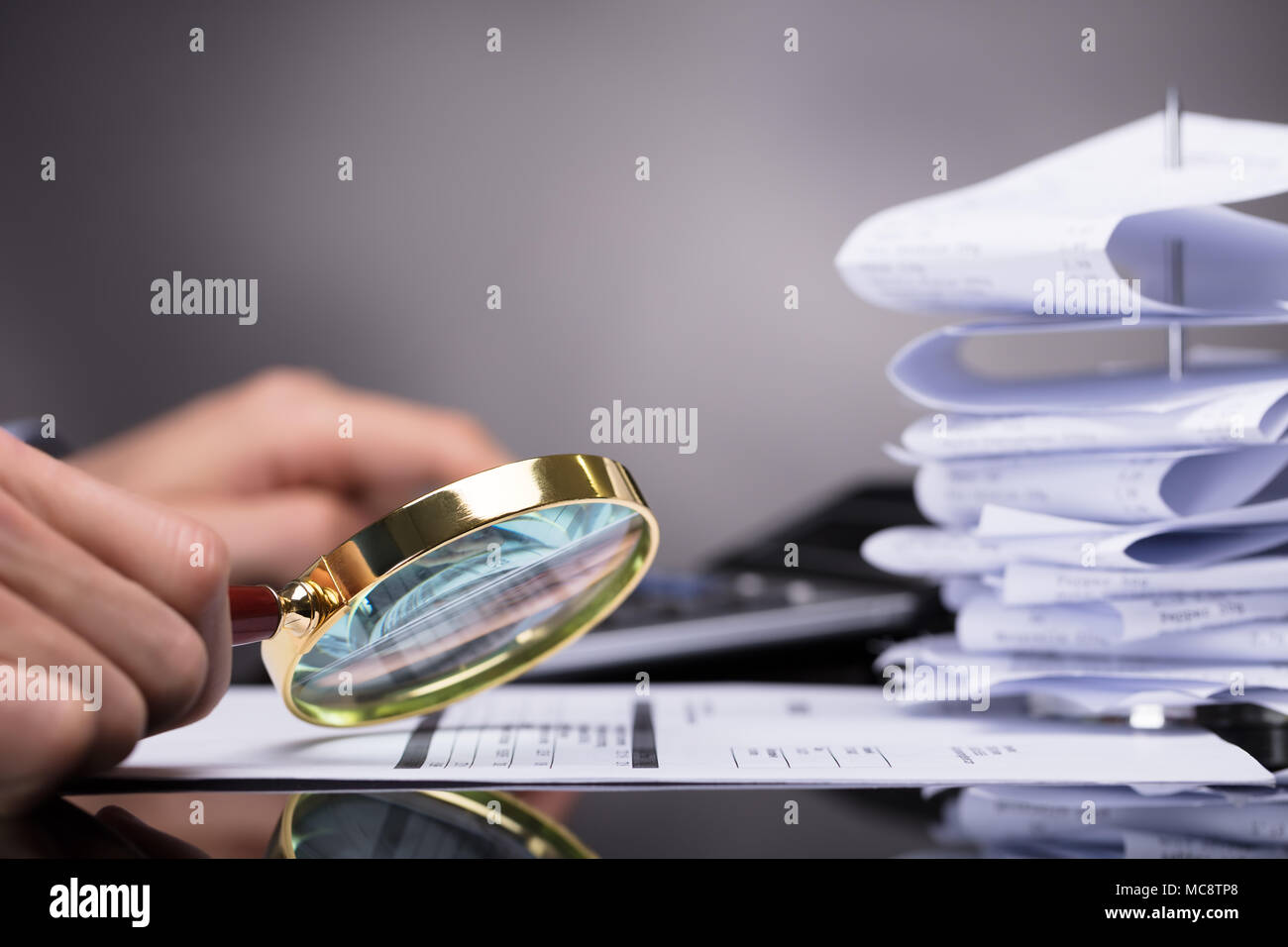 Close-up Of A Businessperson's Hand Looking At Invoice Through ...