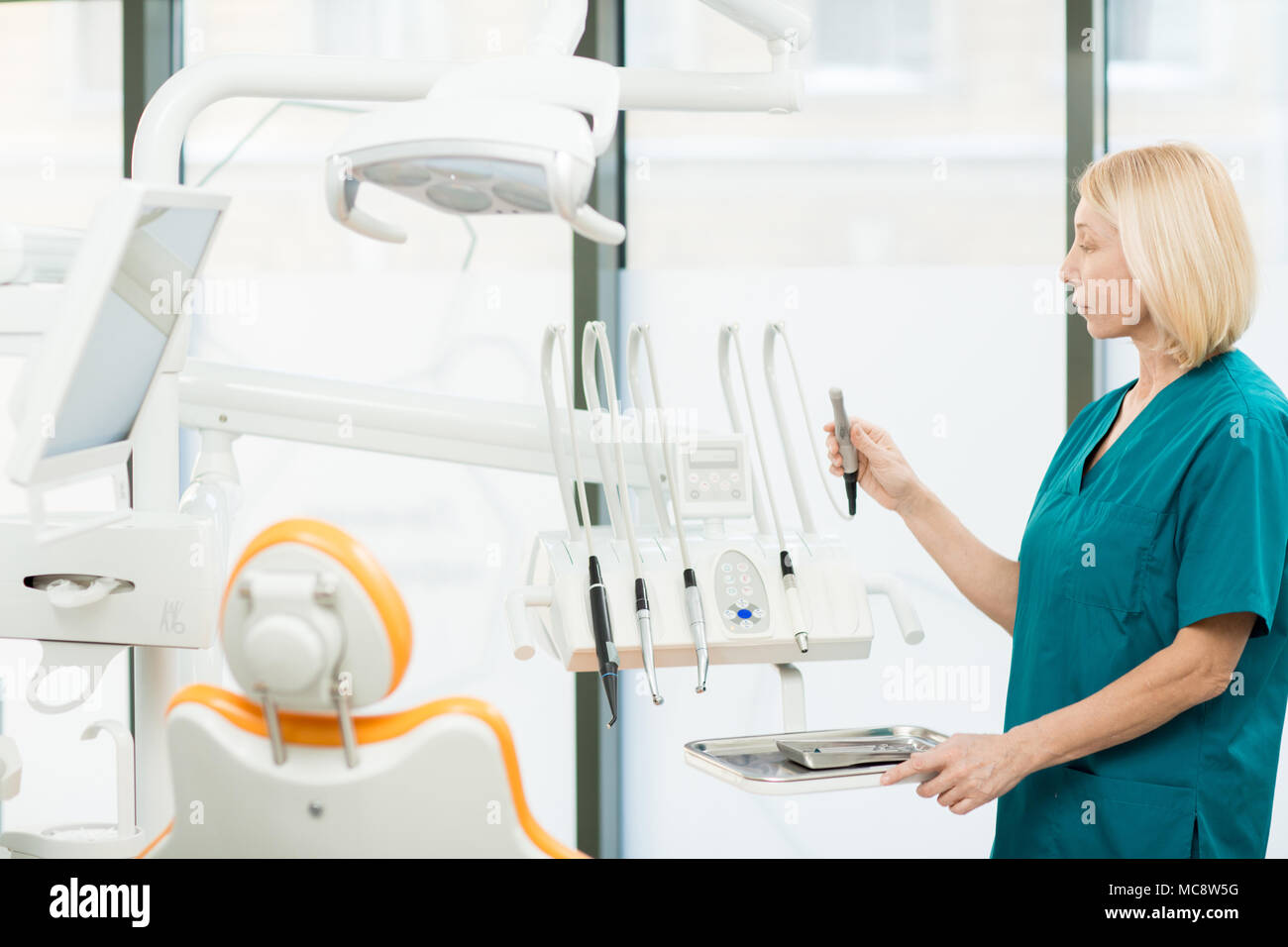 Dentistry nurse checking all the instruments and drills necessary for ...