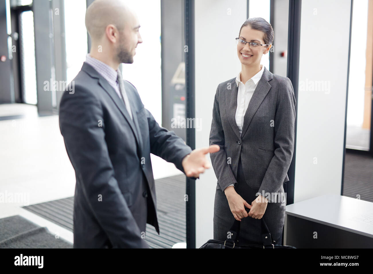 Friendly security guard welcoming one of passengers by gates and ...