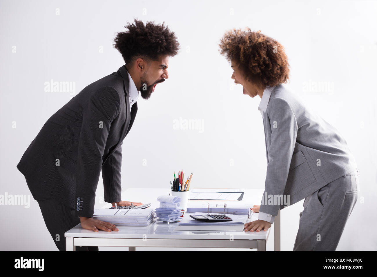 Side View Of Two Young Businesspeople Shouting At Each Other At ...