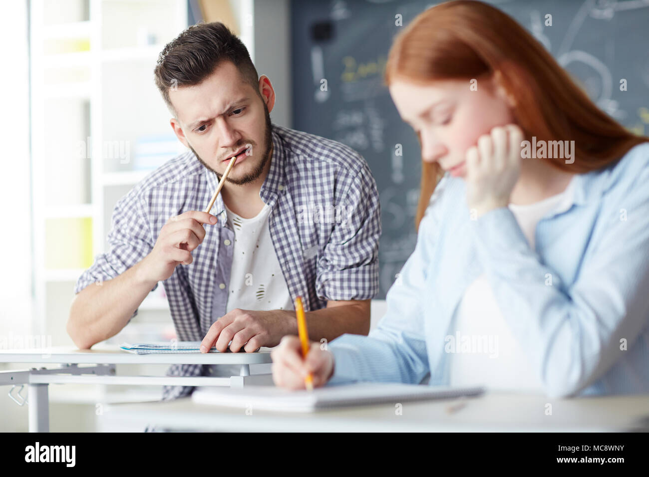 Guy looking at his groupmate notes while writing individual exam test ...