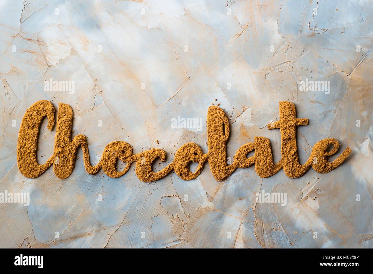 The word chocolate is lined with beautiful cocoa letters on a gray ...