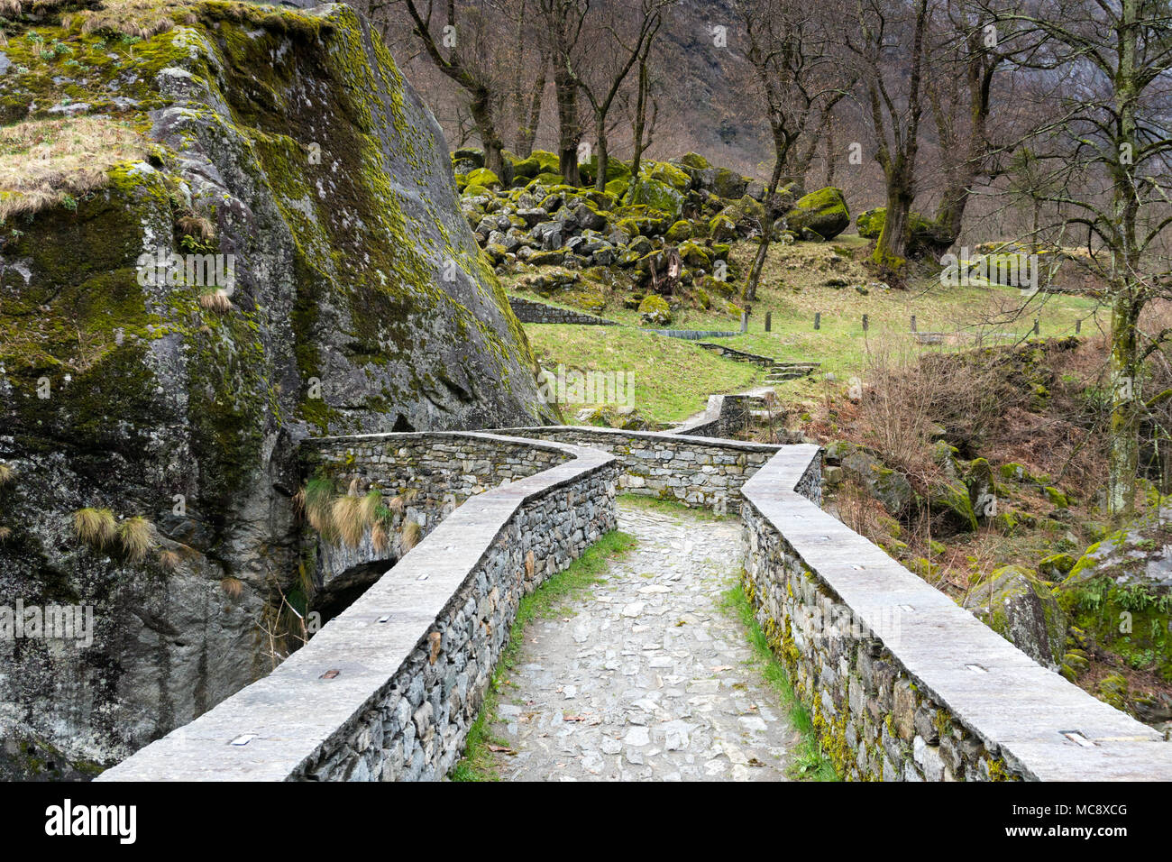 view of beautiful old stone bridge crossing a small mountain stream in ...