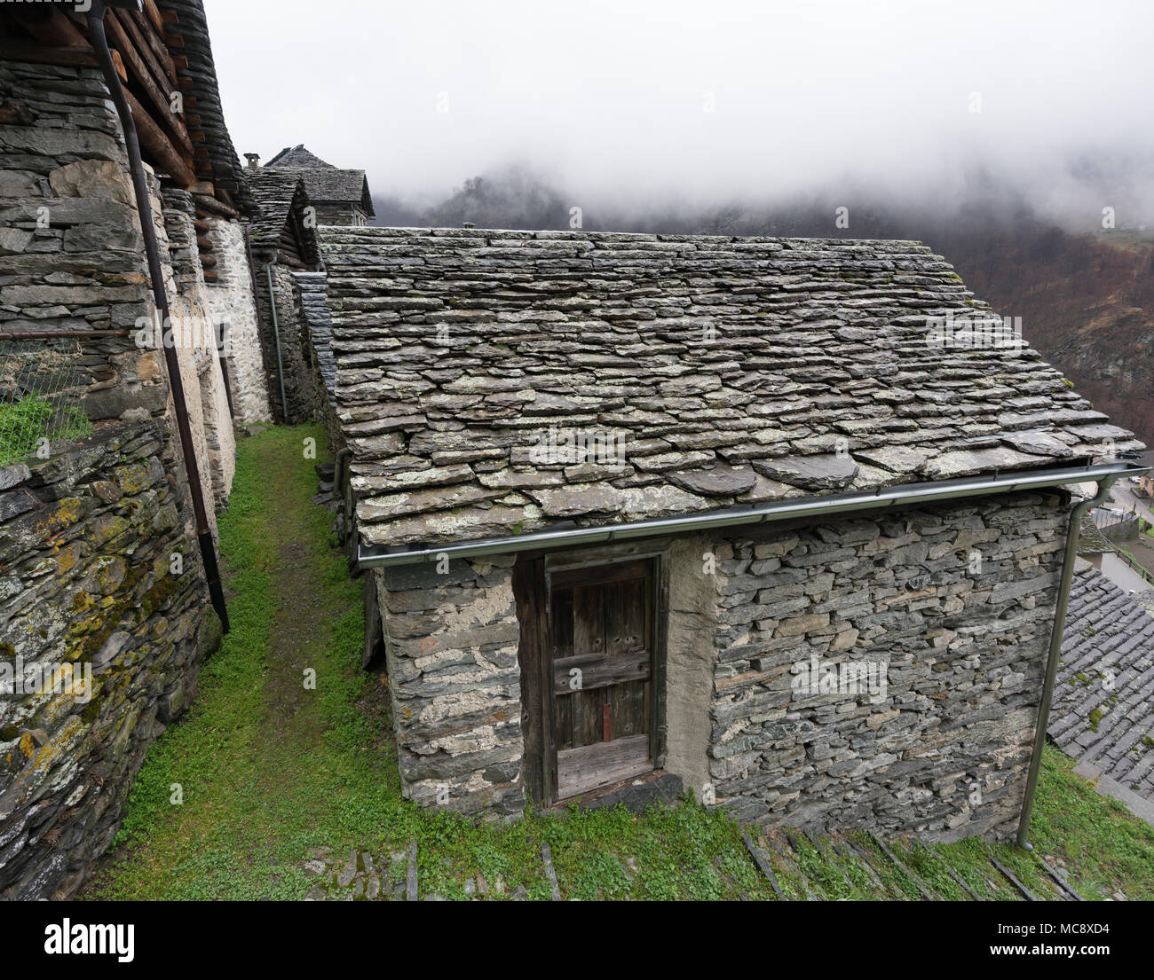 traditional alpine village with many small wooden and stone houses and ...