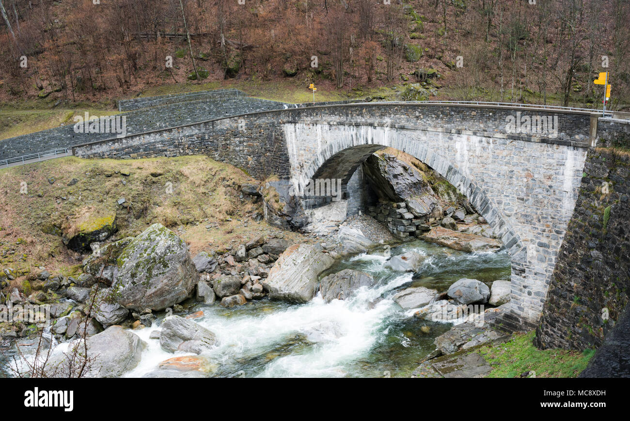 old stone bridge crossing a wild river with trail markers and hiking ...