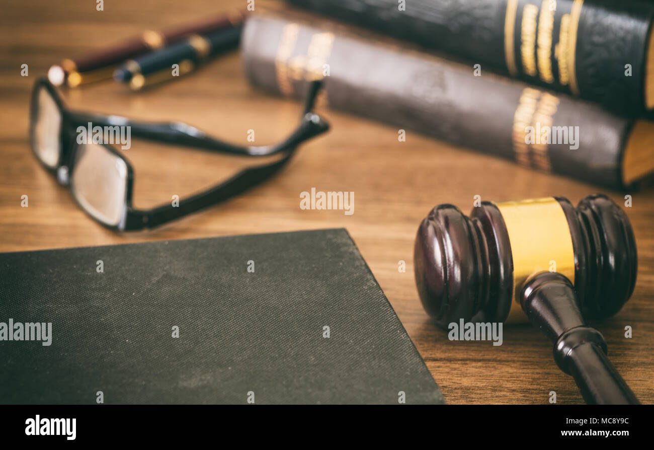 Court room. Law or auction gavel and a hard cover book on a wooden ...