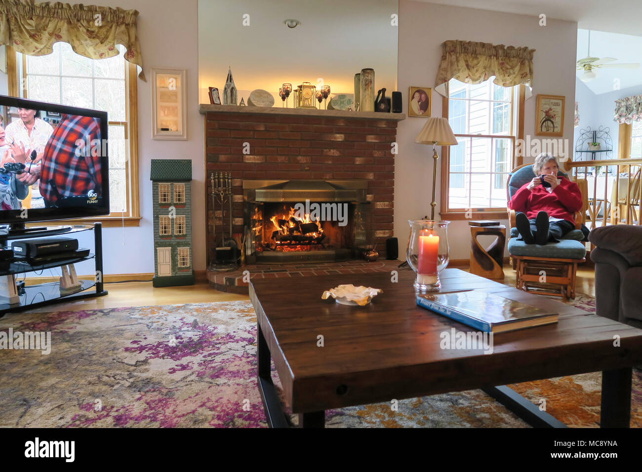 Inviting Family Room with Fire in Fireplace, USA Stock Photo - Alamy