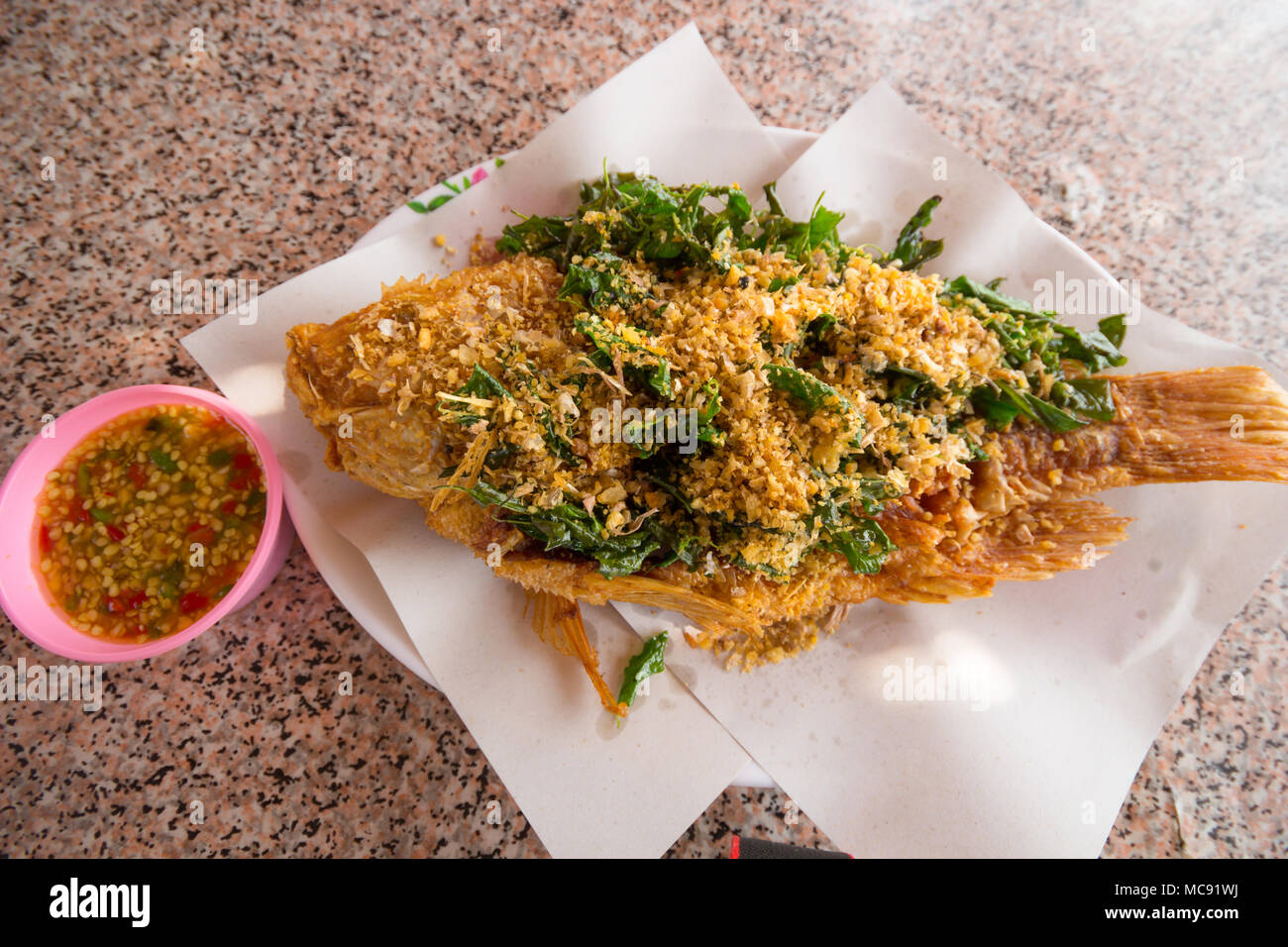Fried fish with garlic on plat Stock Photo - Alamy
