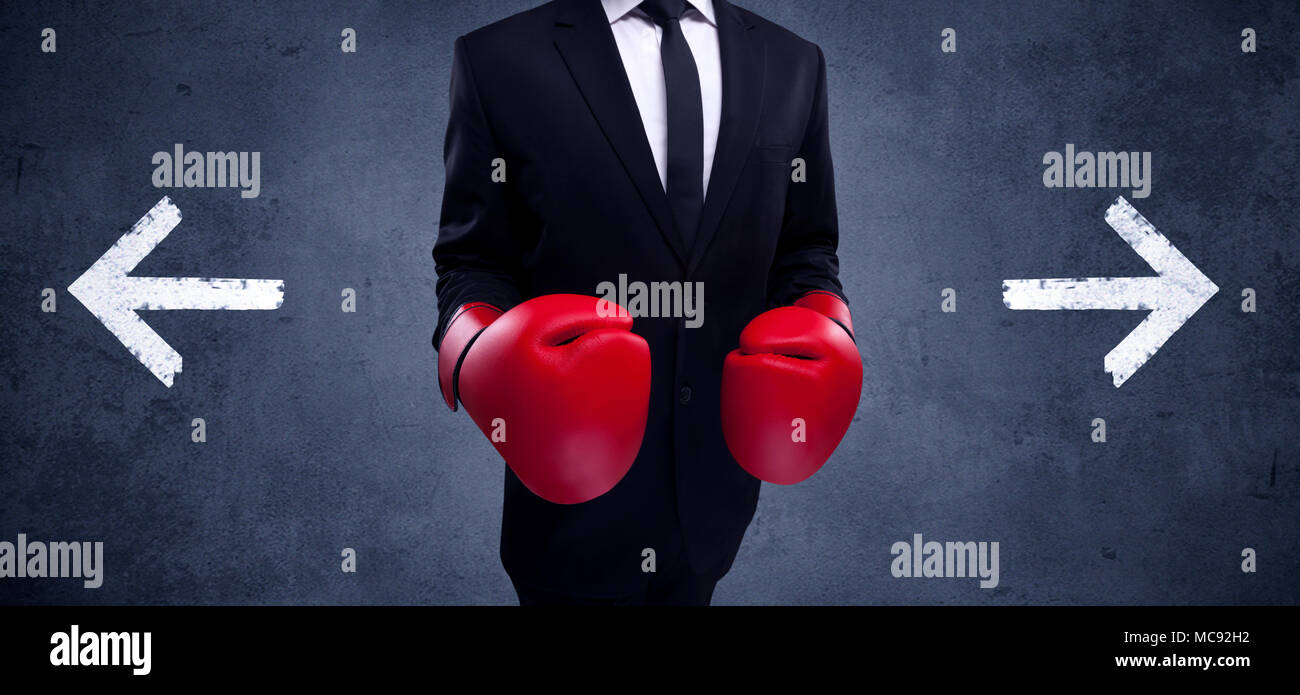 A confident businessman standing with red boxing gloves on his hand in ...