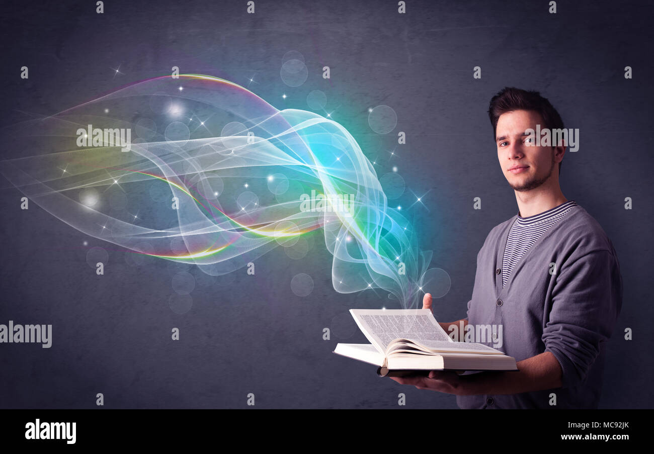 Casual young man holding book with rainbow waves flying out of it Stock ...