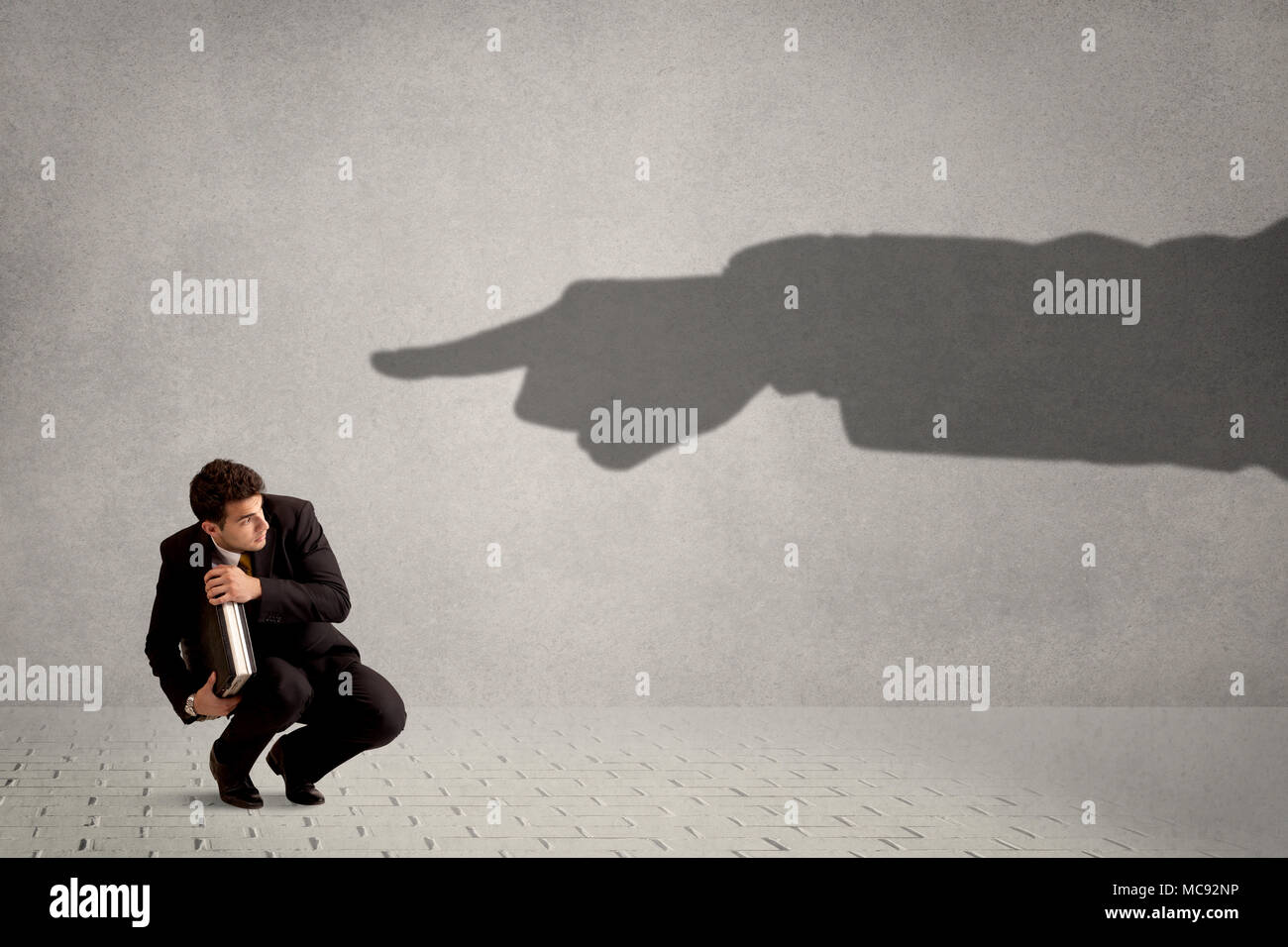 Business person looking at huge shadow hand pointing at him concept on ...