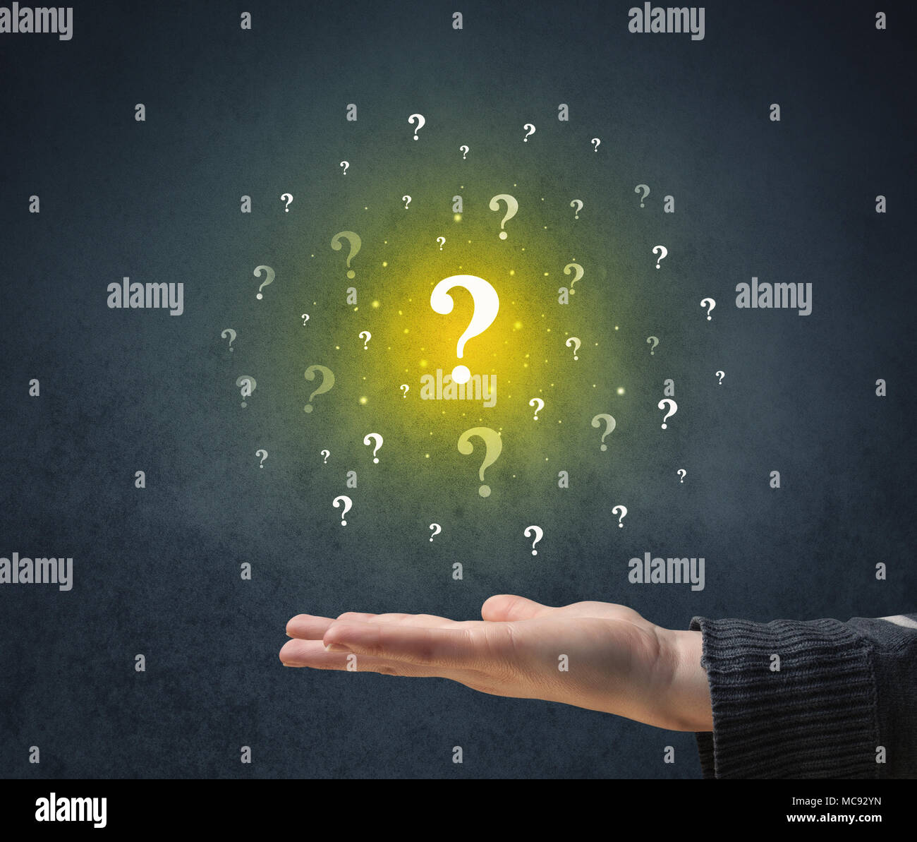 Yellow question marks hovering over young hand Stock Photo - Alamy