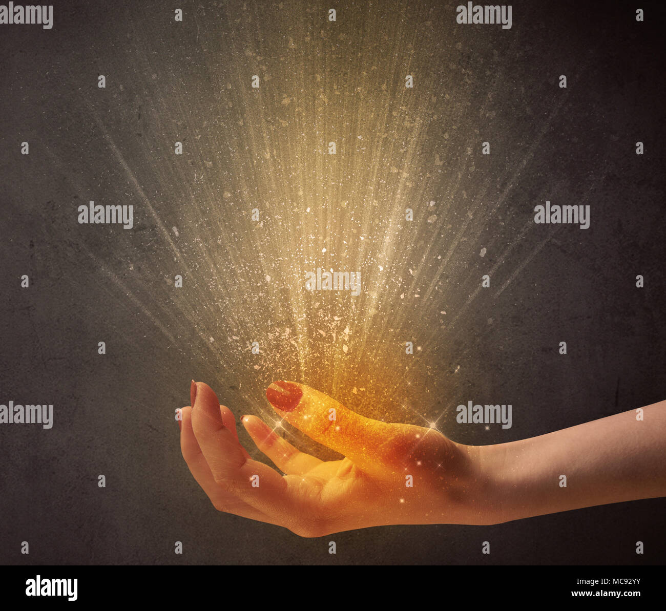 Yellow ray of light coming from a young hand Stock Photo - Alamy