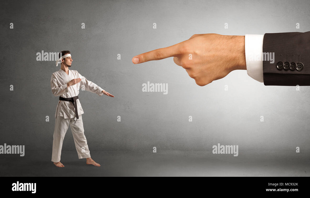 Small karate man fighting with big hand Stock Photo - Alamy
