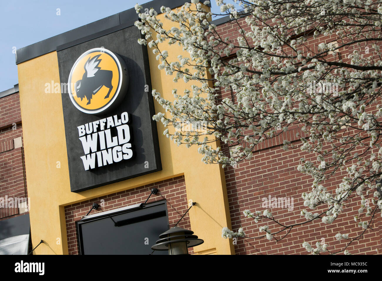 A logo sign outside of a Buffalo Wild Wings restaurant location in ...