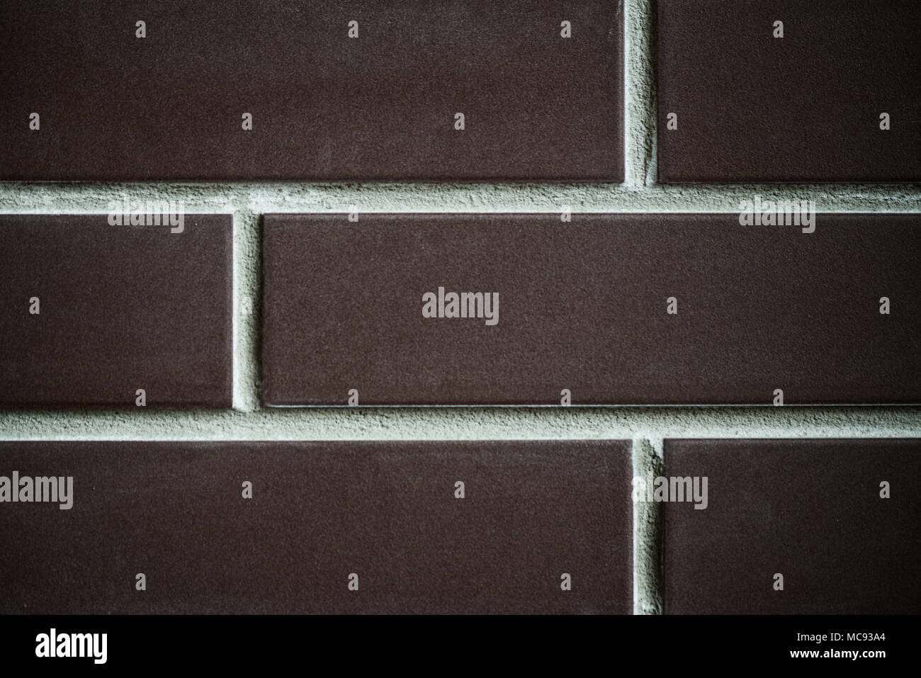 background of a brick dark wall, tile texture with a smooth pattern ...