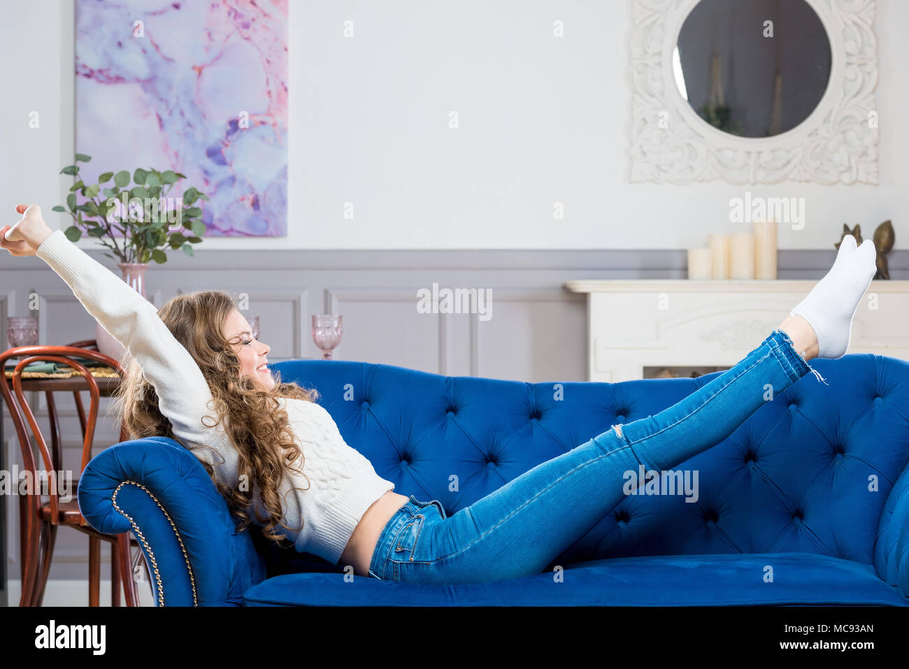 slender and beautiful woman stretches out on the couch Stock Photo - Alamy