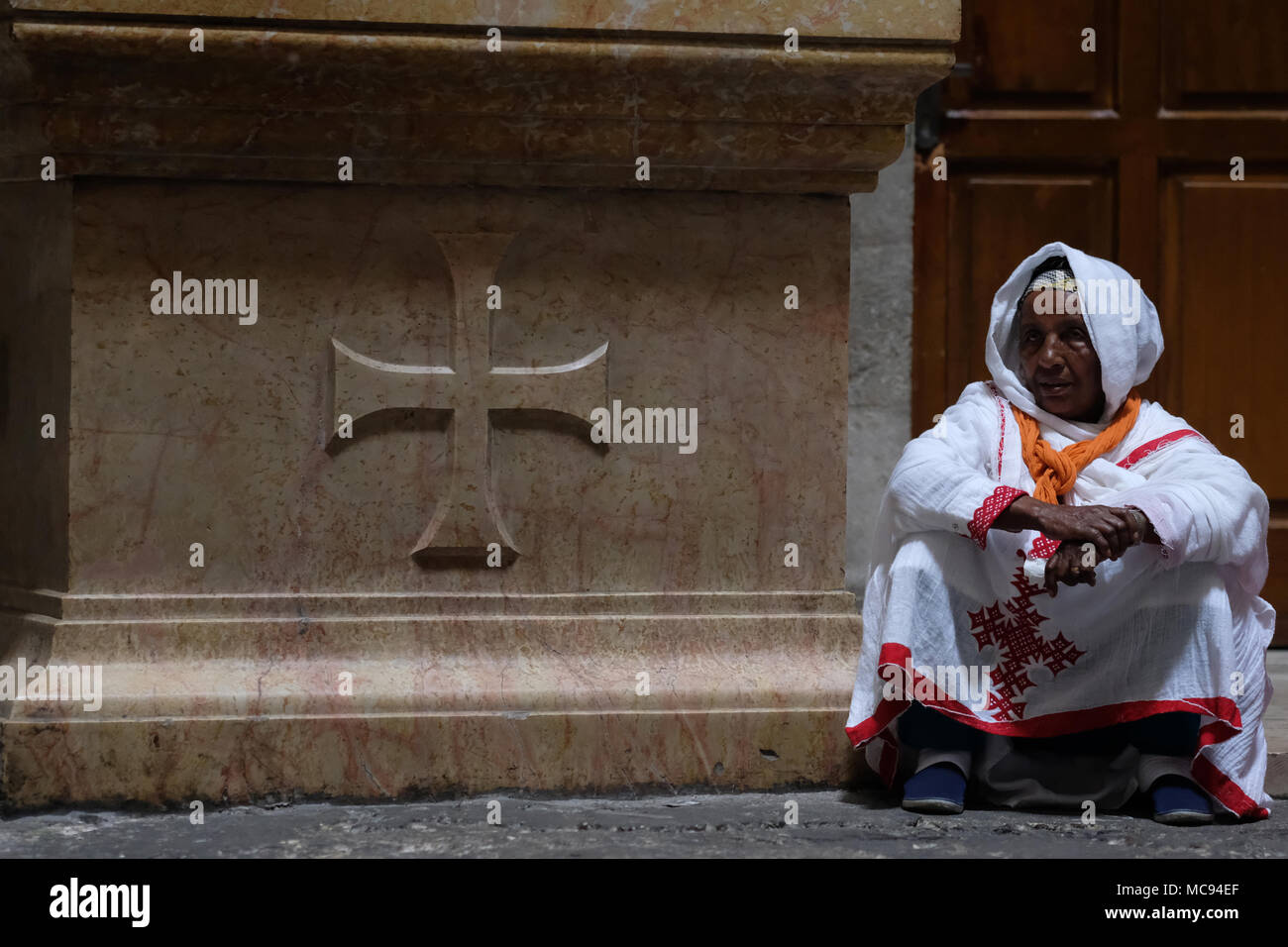 An elderly Christian pilgrim from Ethiopia sit aside a carved Bolnisi ...