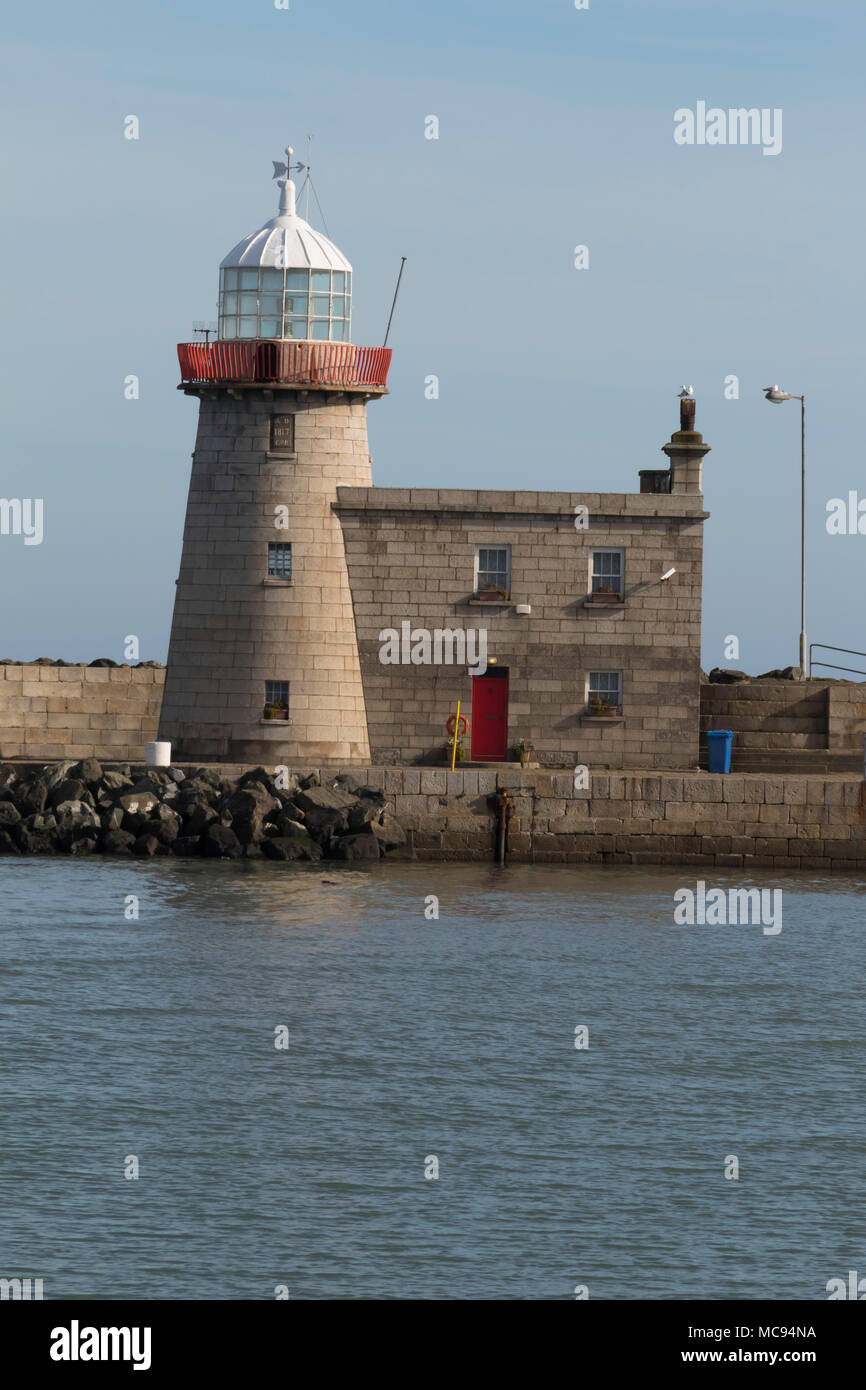 Old Lighthouse view with red door, sunny morning, blue sky, harbour ...