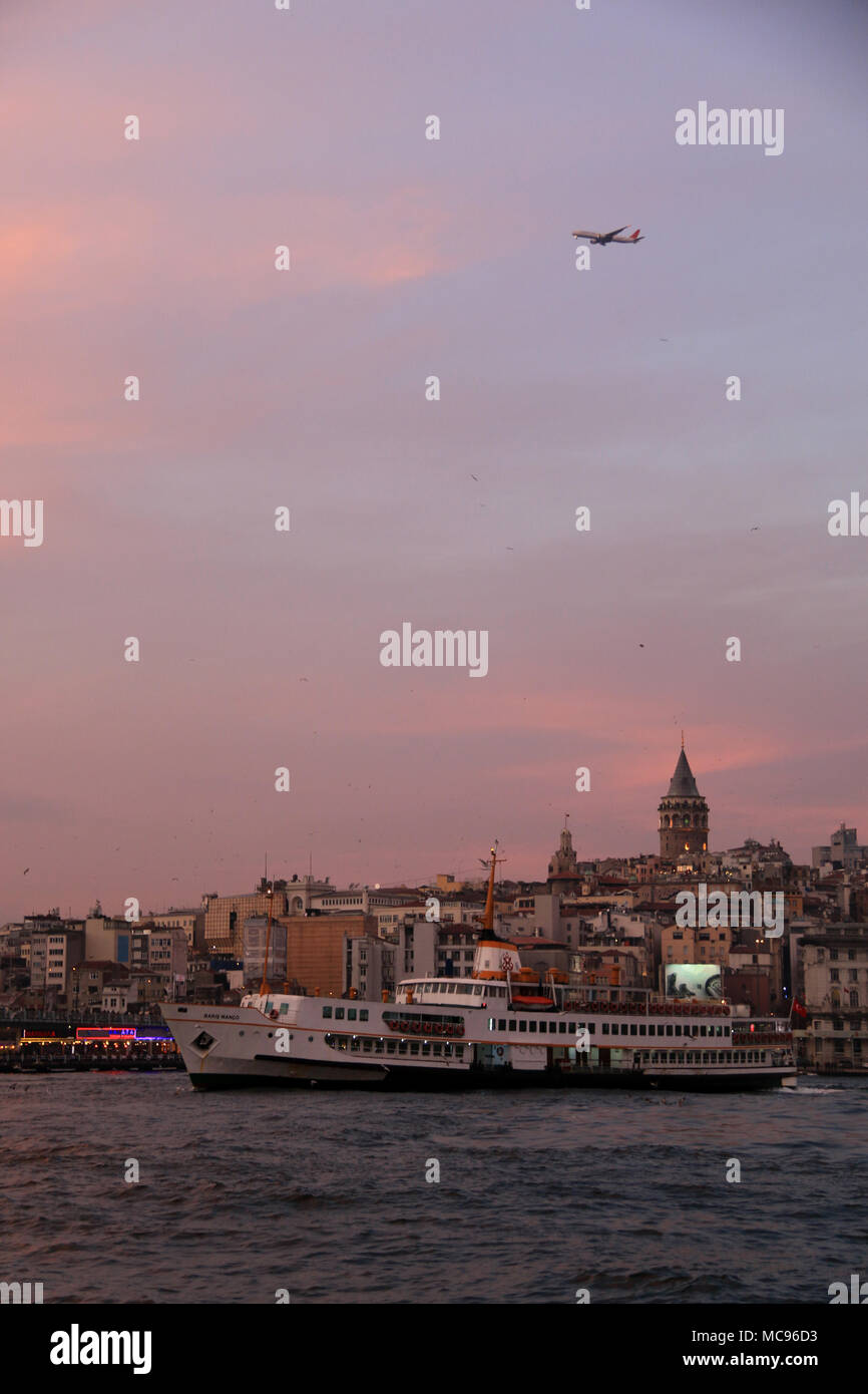 Ferry "Barış Manço" navigating through the Golden Horn, while a Boeing ...