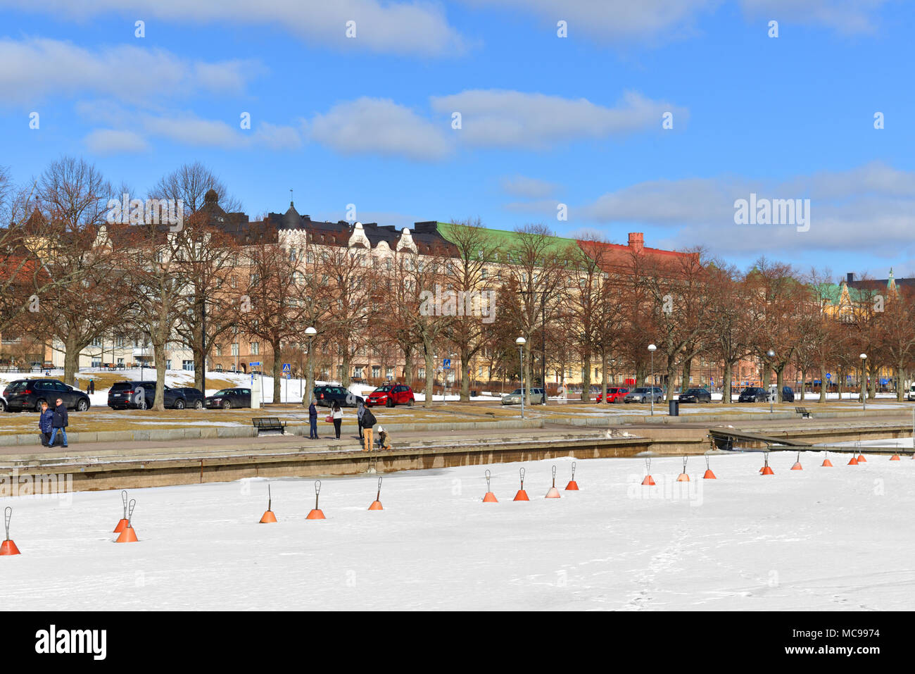 Residents of city and tourists walk along embankment in early spring ...