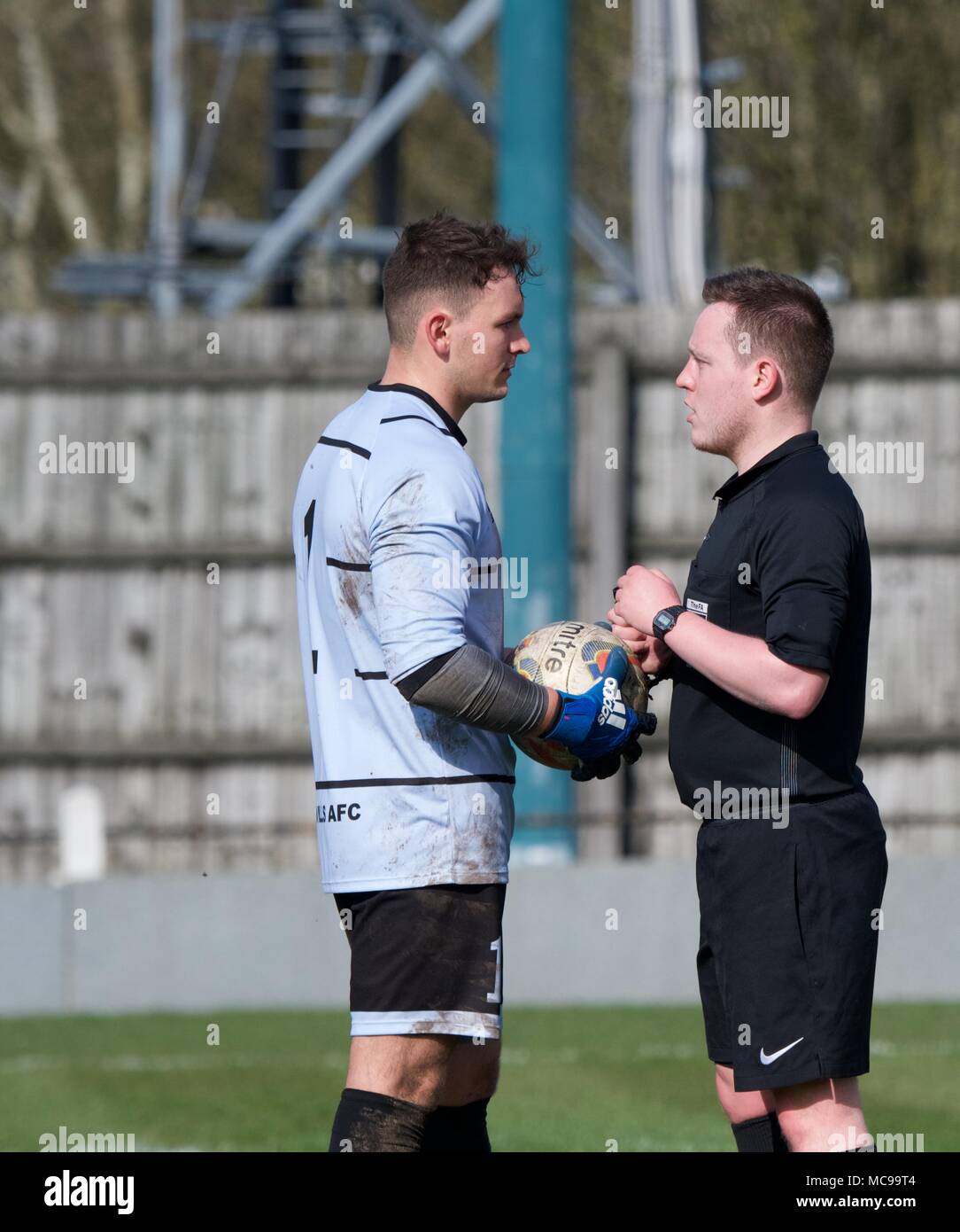 The referee speaks to the New Mills FC goalkeeper about time-wasting ...
