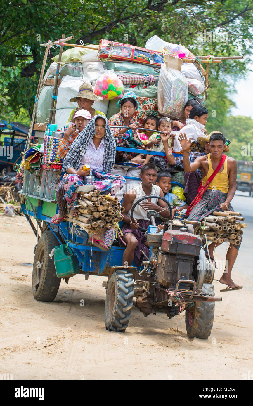 Burmese farmers riding on an old tractor in a village in Shan state ...